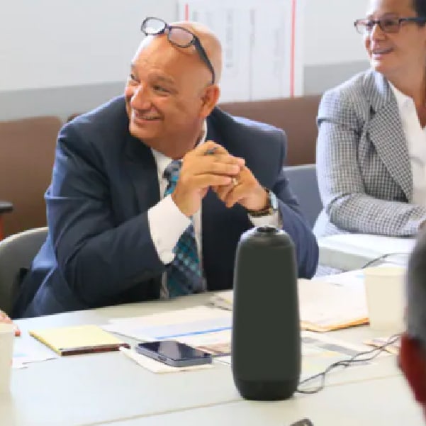 male in navy suit smiling to the left of him with glasses on top of ...